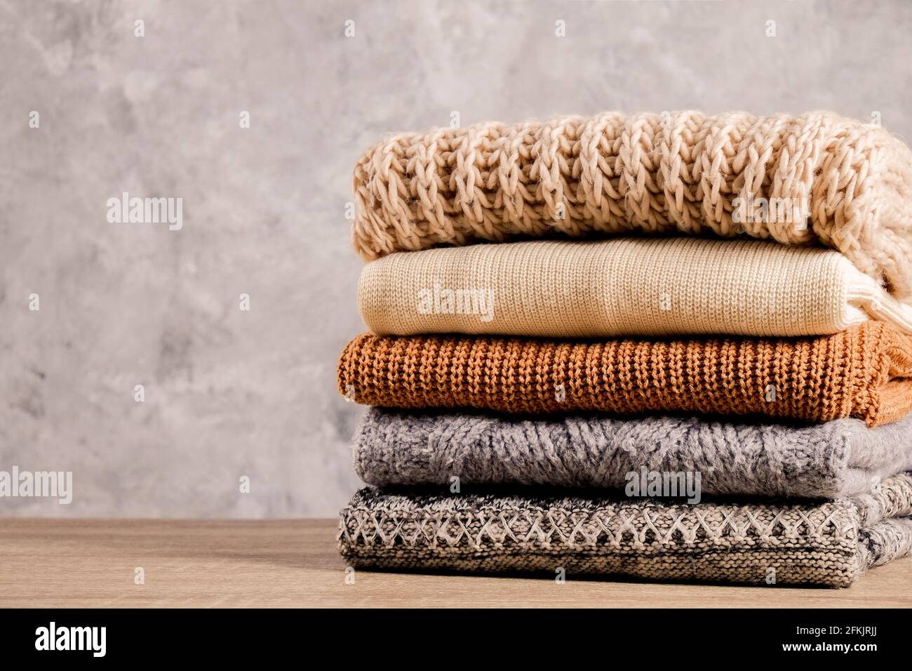 Bunch of knitted warm pastel color sweaters with different knitting ...