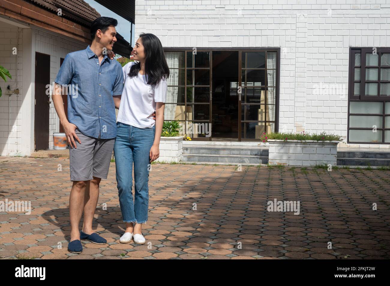 Happy couple in front of the New Home On Moving In Day, and start a new ...