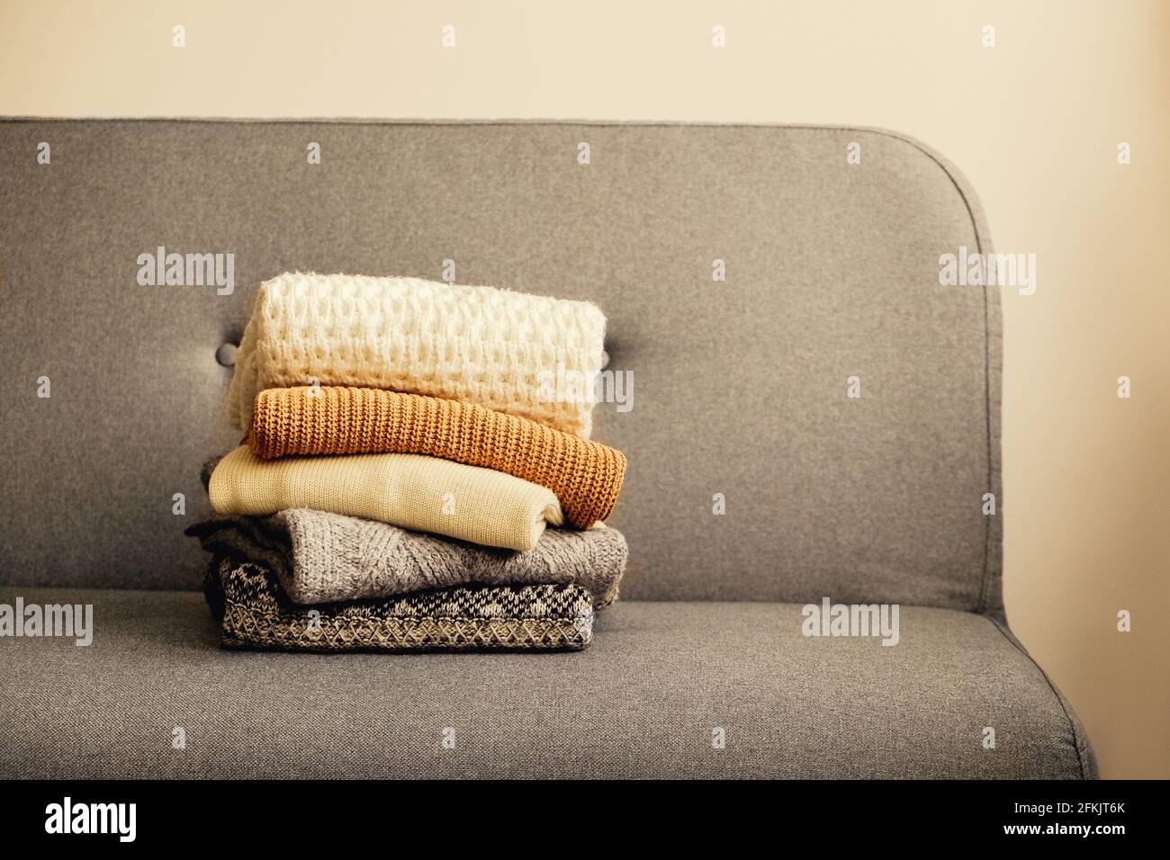 Bunch of knitted warm pastel color sweaters, different knitting ...