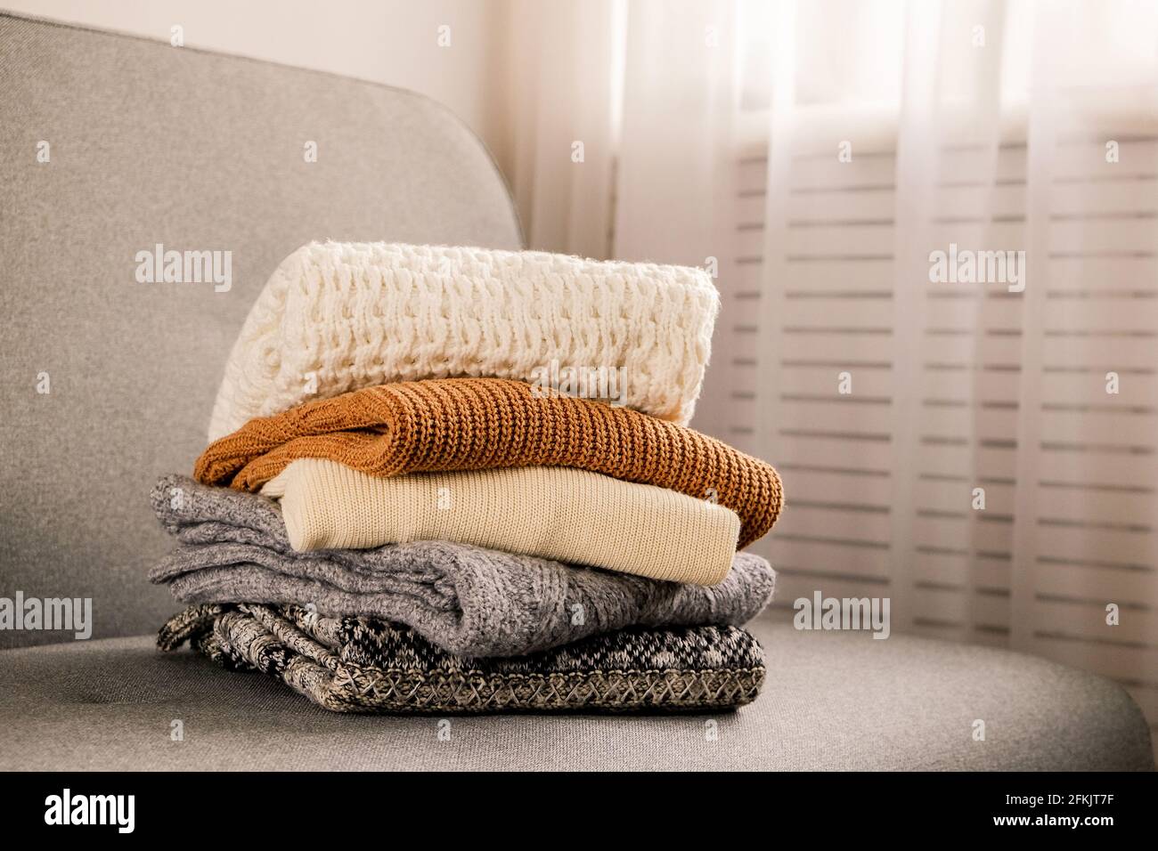 Bunch of knitted warm pastel color sweaters, different knitting ...