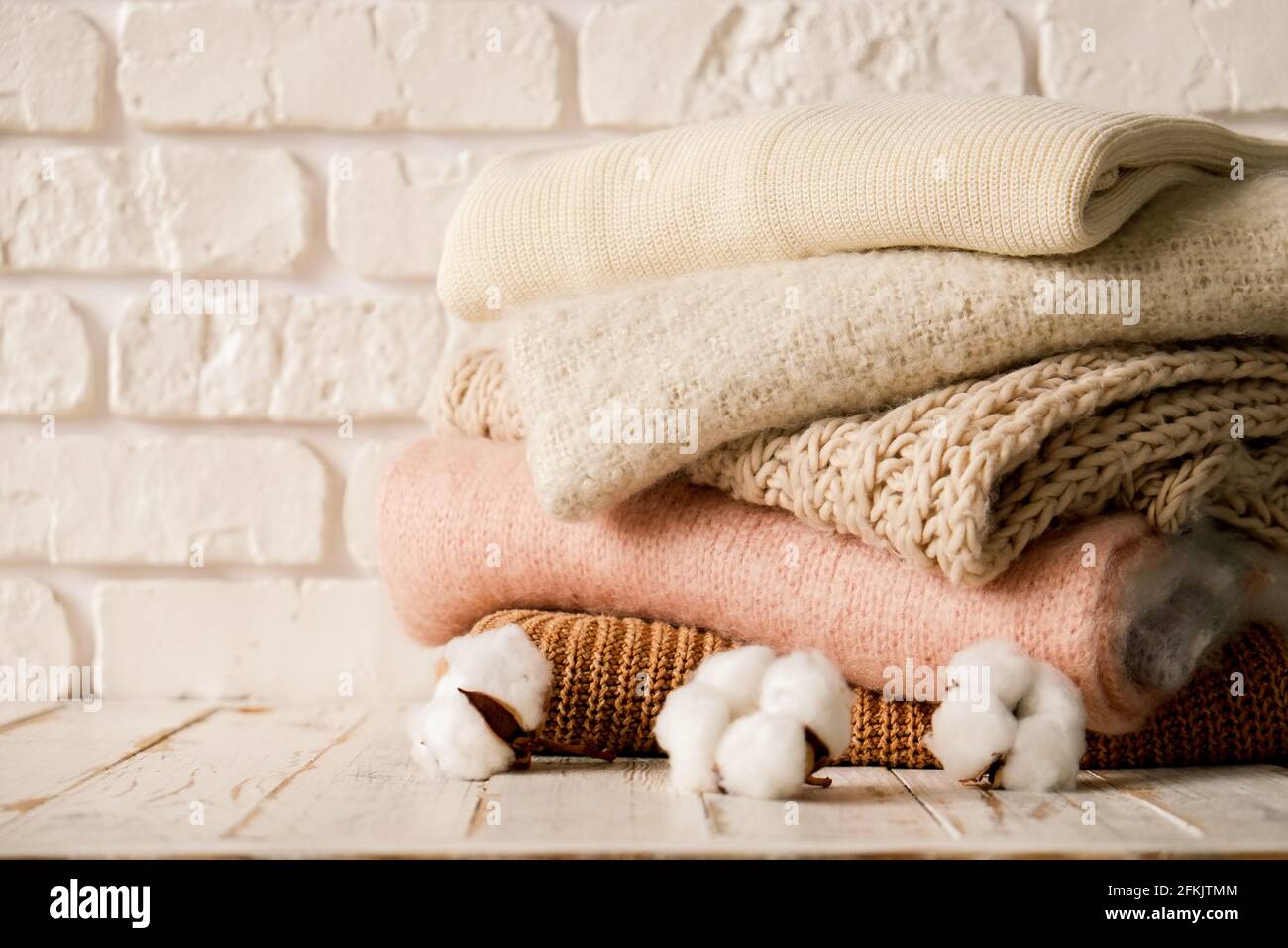 Bunch of knitted warm pastel color sweaters, different knitting ...
