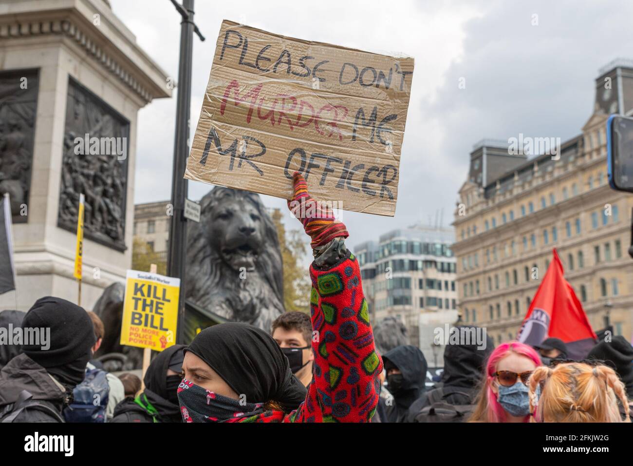 Protester in Trafalgar Square holds sign reading “PLEASE DON'T MURDER ...