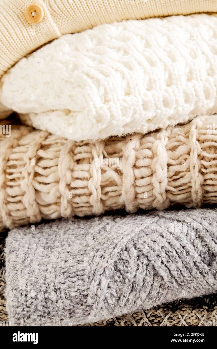 Bunch of knitted warm pastel color sweaters with different knitting ...