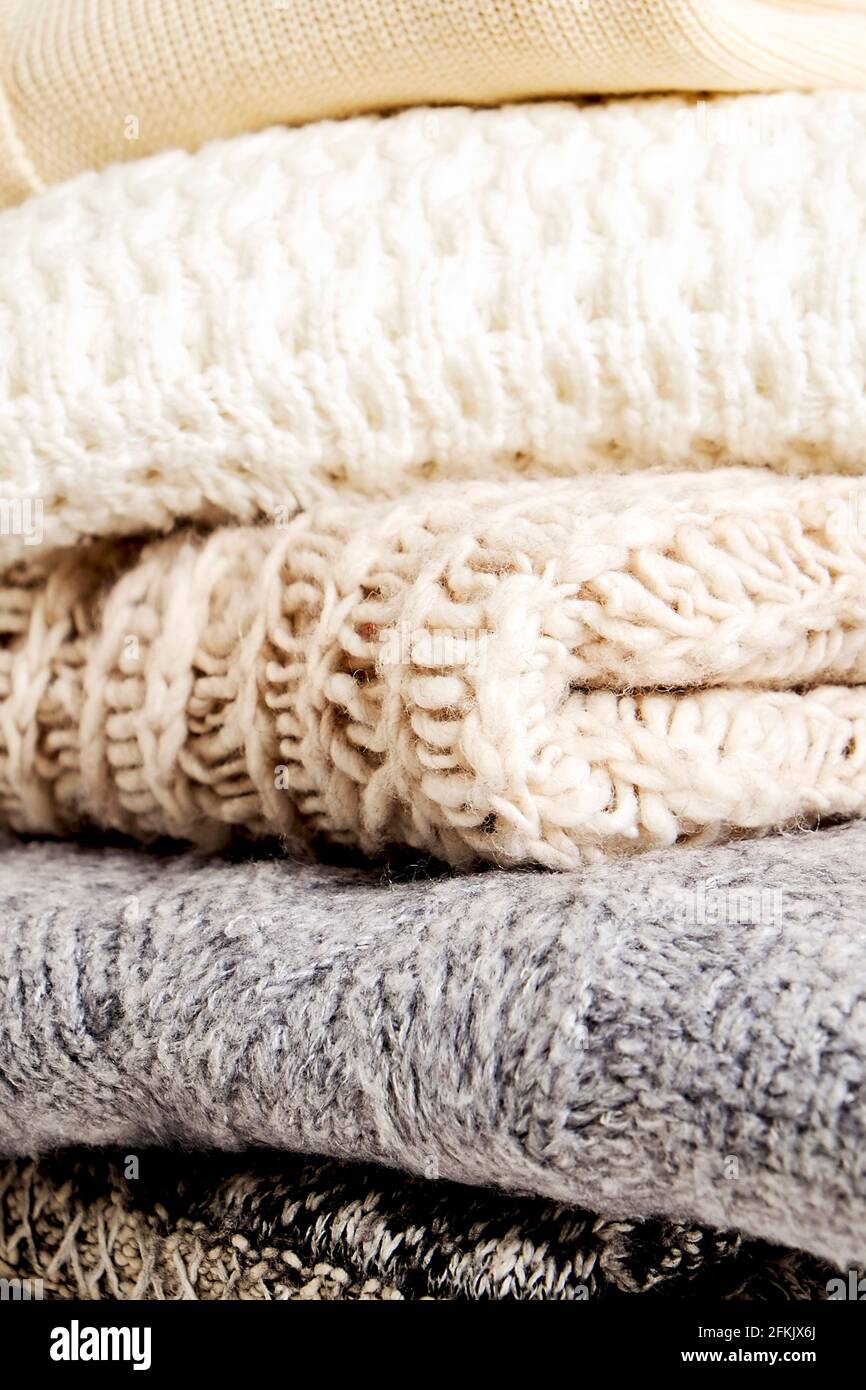 Bunch of knitted warm pastel color sweaters with different knitting ...