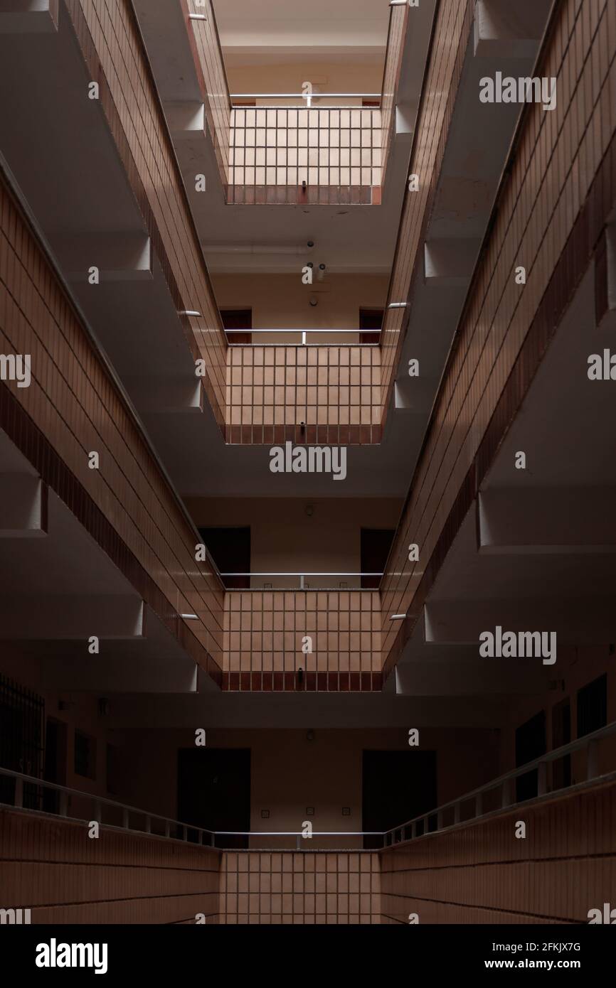 A vertical shot of a multi-floor hallway with open balconies of all ...