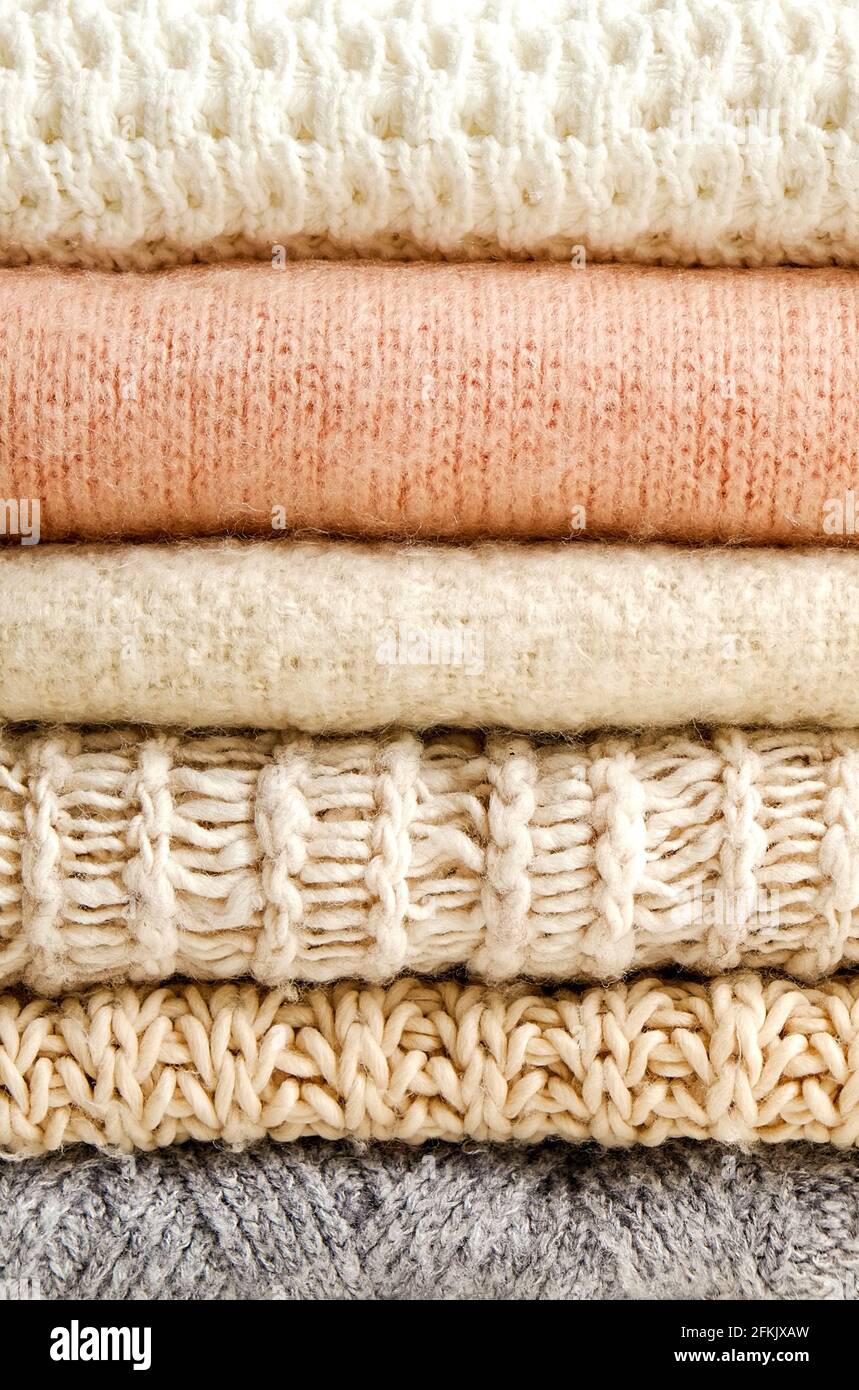 Bunch of knitted warm pastel color sweaters with different knitting ...