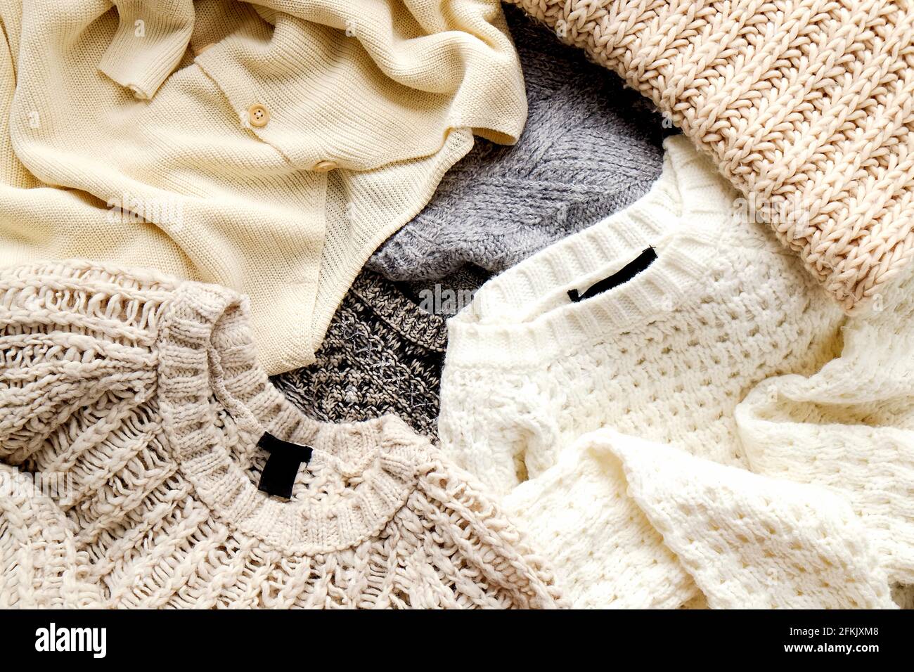 Bunch of knitted warm pastel color sweaters with different knitting ...