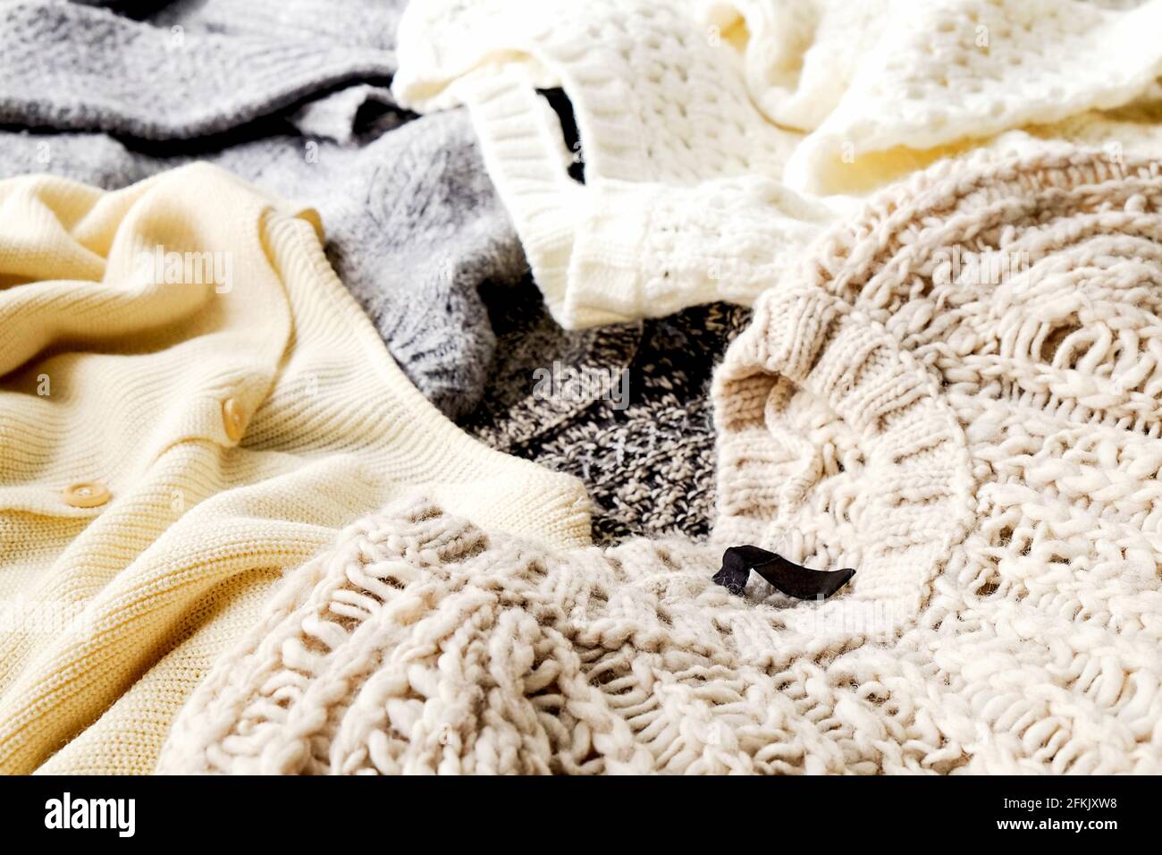 Bunch of knitted warm pastel color sweaters with different knitting ...