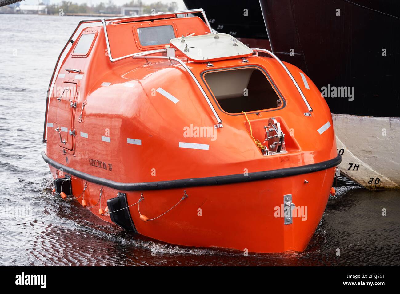 Totally Enclosed Lifeboat floating near big vessel Stock Photo - Alamy