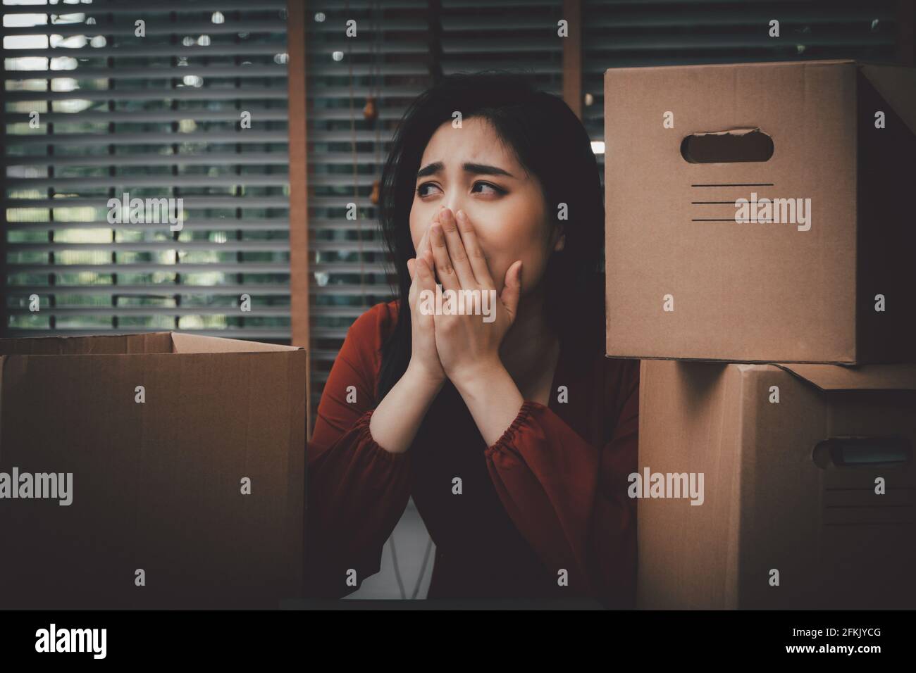 Sad Asian woman Packing belongings in a cardboard box and crying on the ...