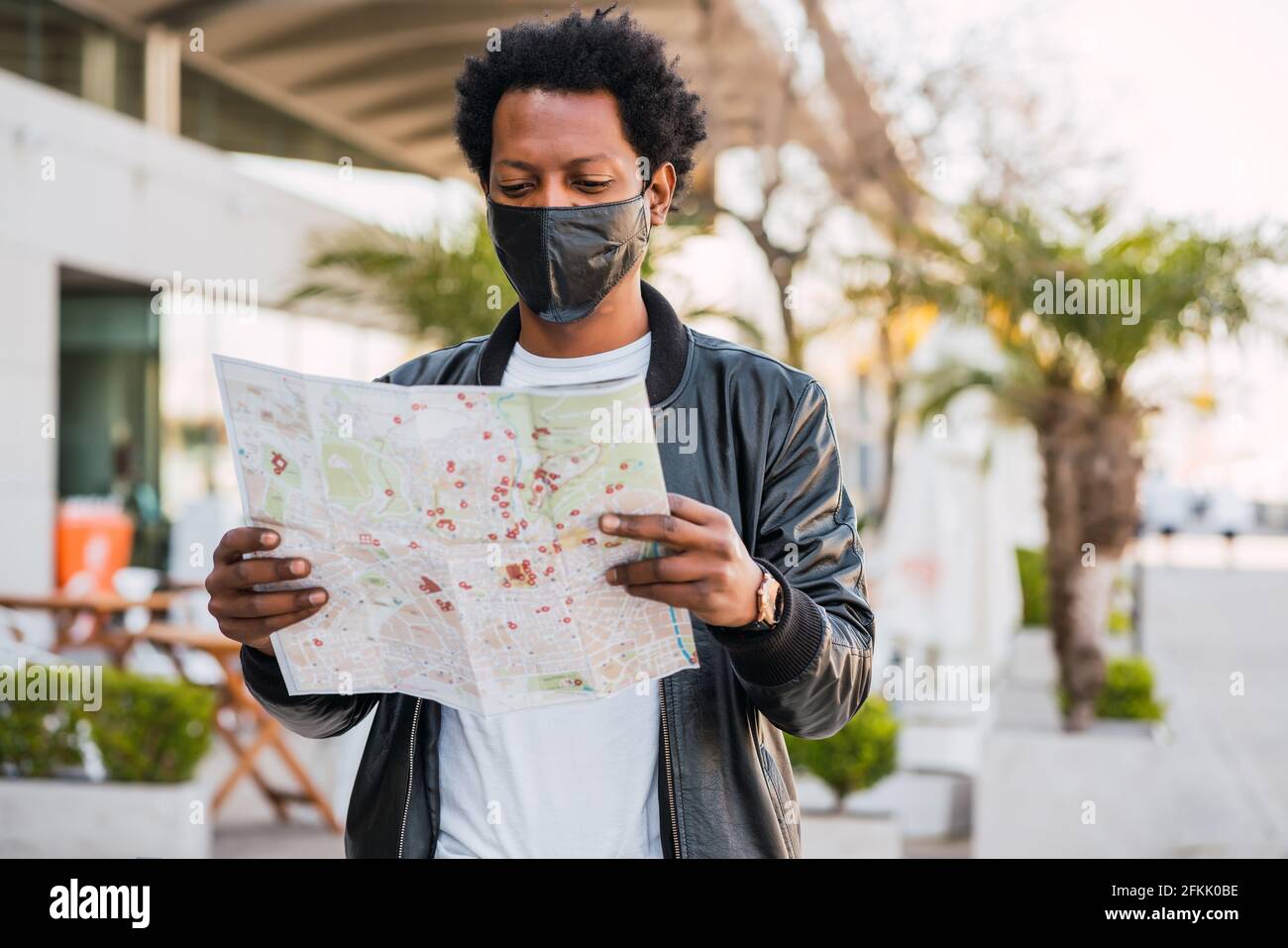 Tourist man looking for directions on map Stock Photo - Alamy