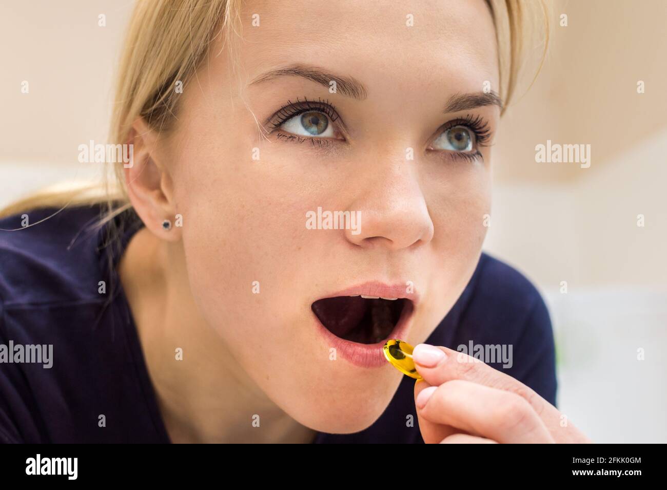 Woman face with vitamin omega 3 close up Stock Photo - Alamy