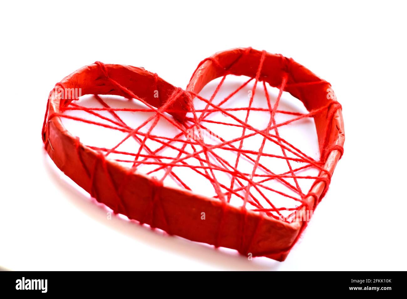 A paper heart tied with red threads. Heart on a white background Stock ...