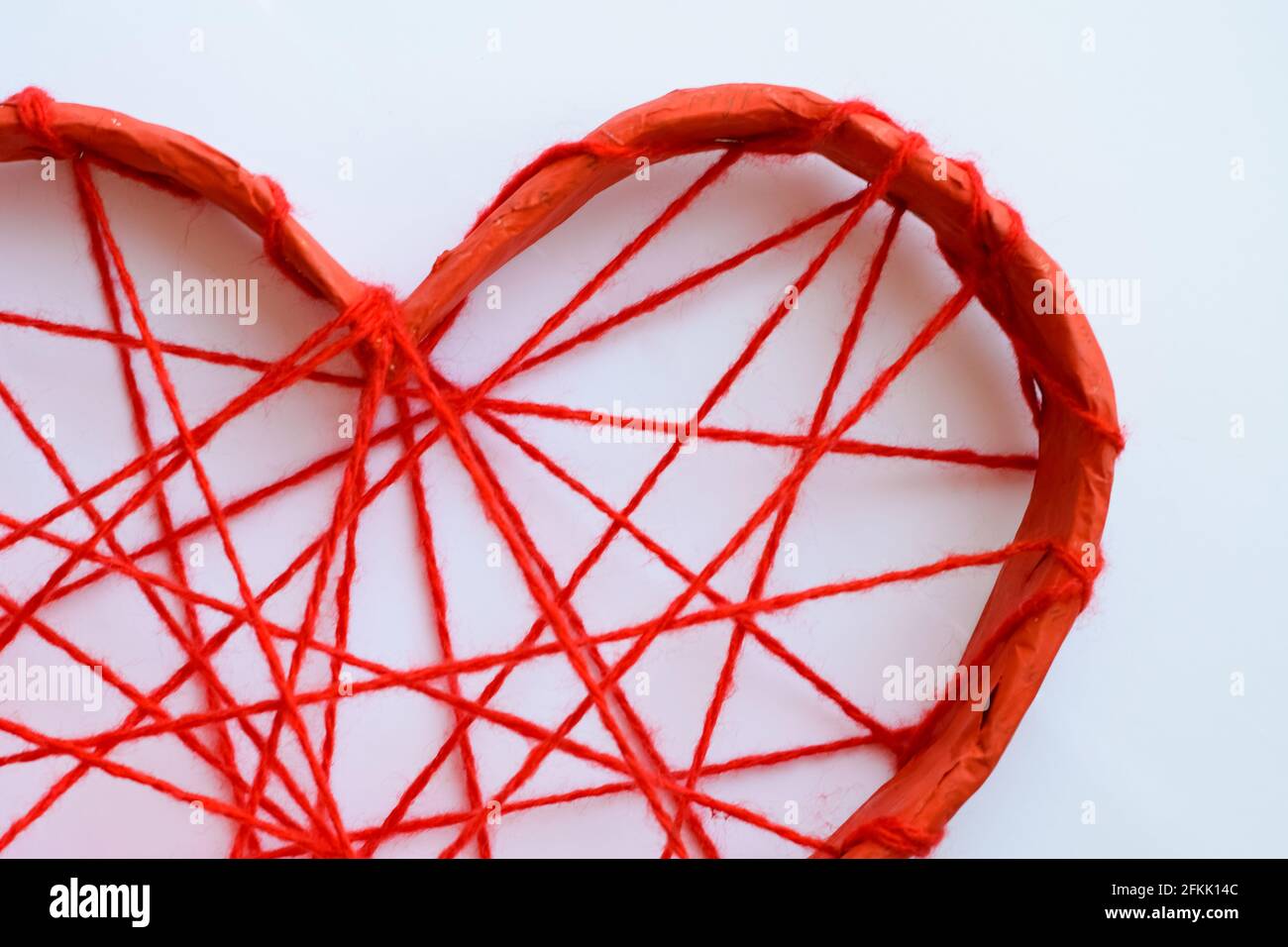 A paper heart tied with red threads. Heart on a white background Stock ...