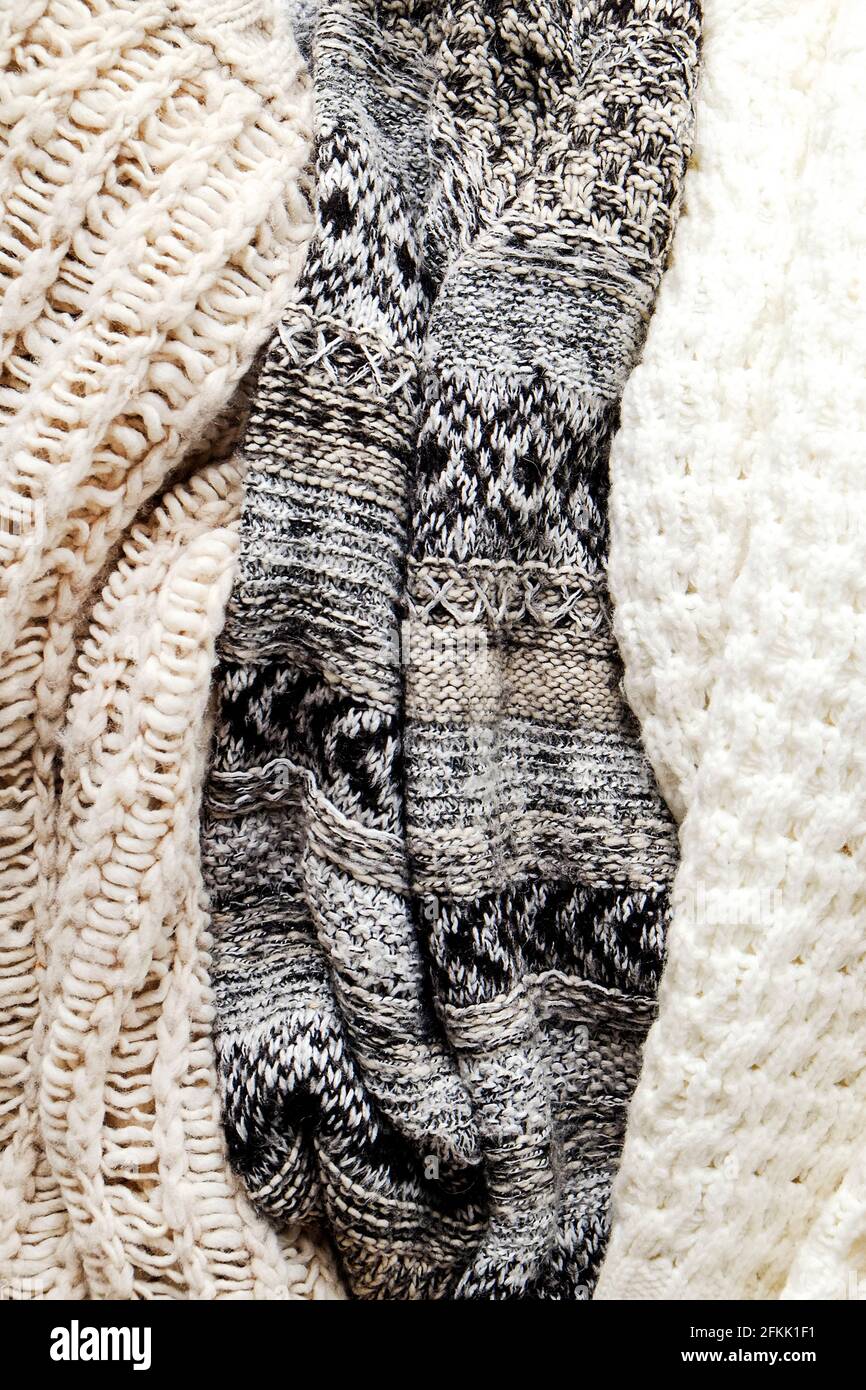 Bunch of knitted warm pastel color sweaters with different knitting ...