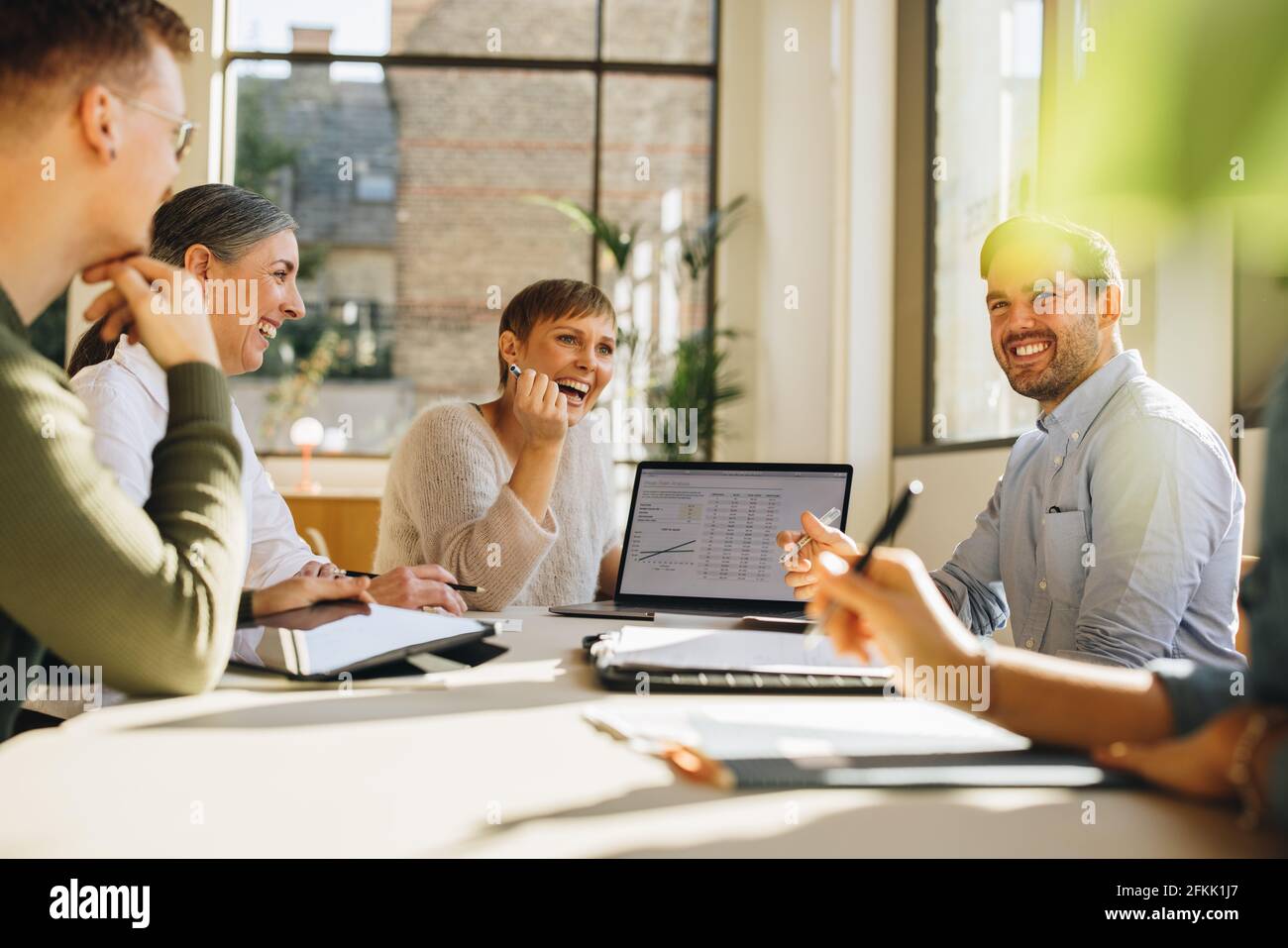 Cheerful business team meeting for strategy planning. Happy men and women discussing new ...