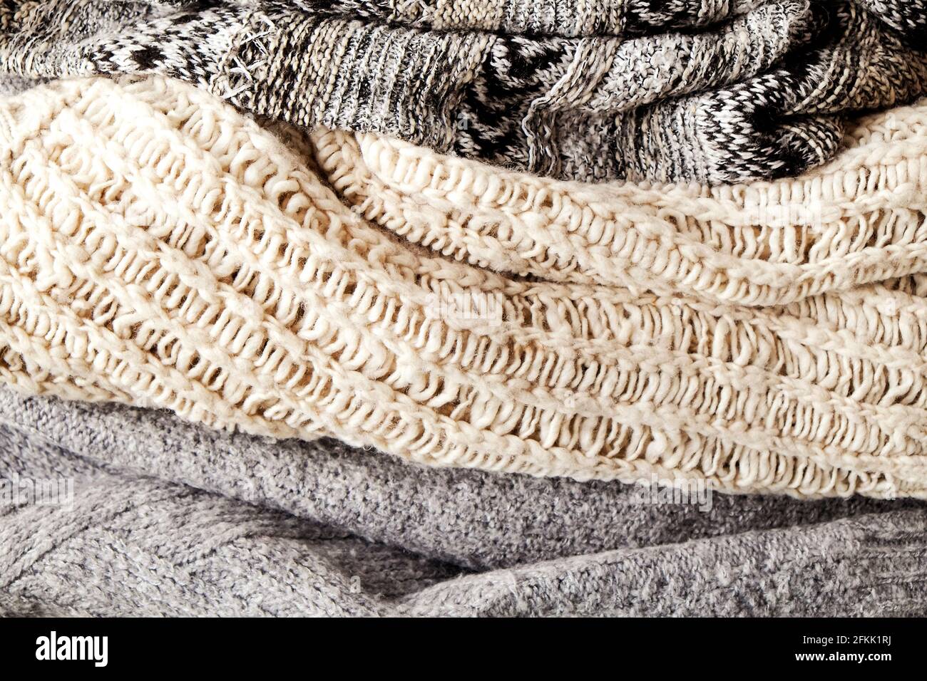 Bunch of knitted warm pastel color sweaters with different knitting ...