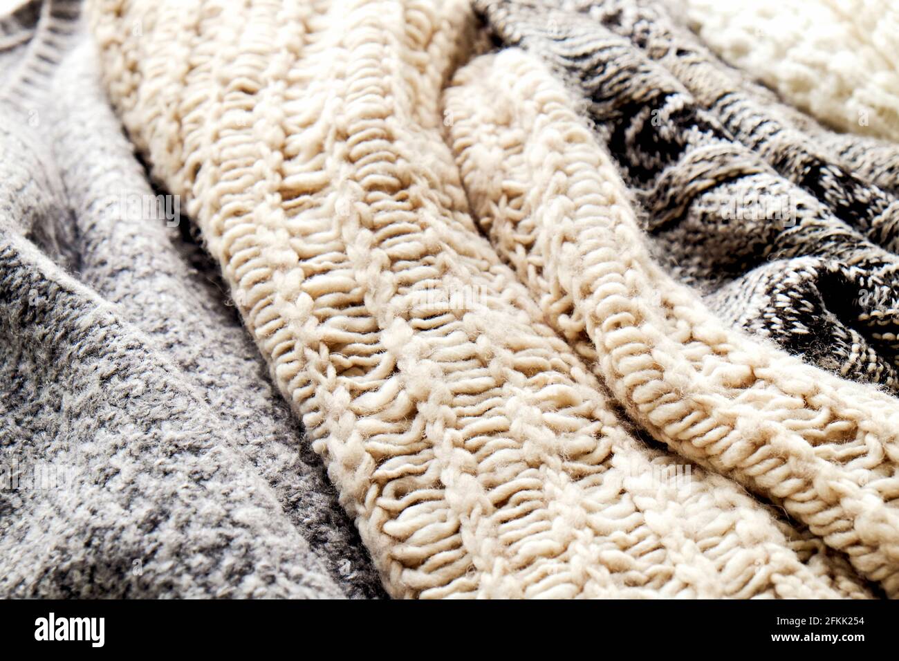 Bunch of knitted warm pastel color sweaters with different knitting ...