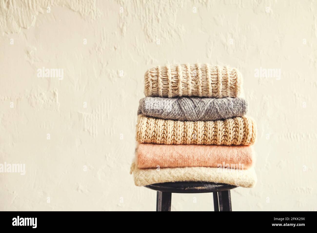 Bunch of knitted pastel color sweaters, different knitting patterns ...