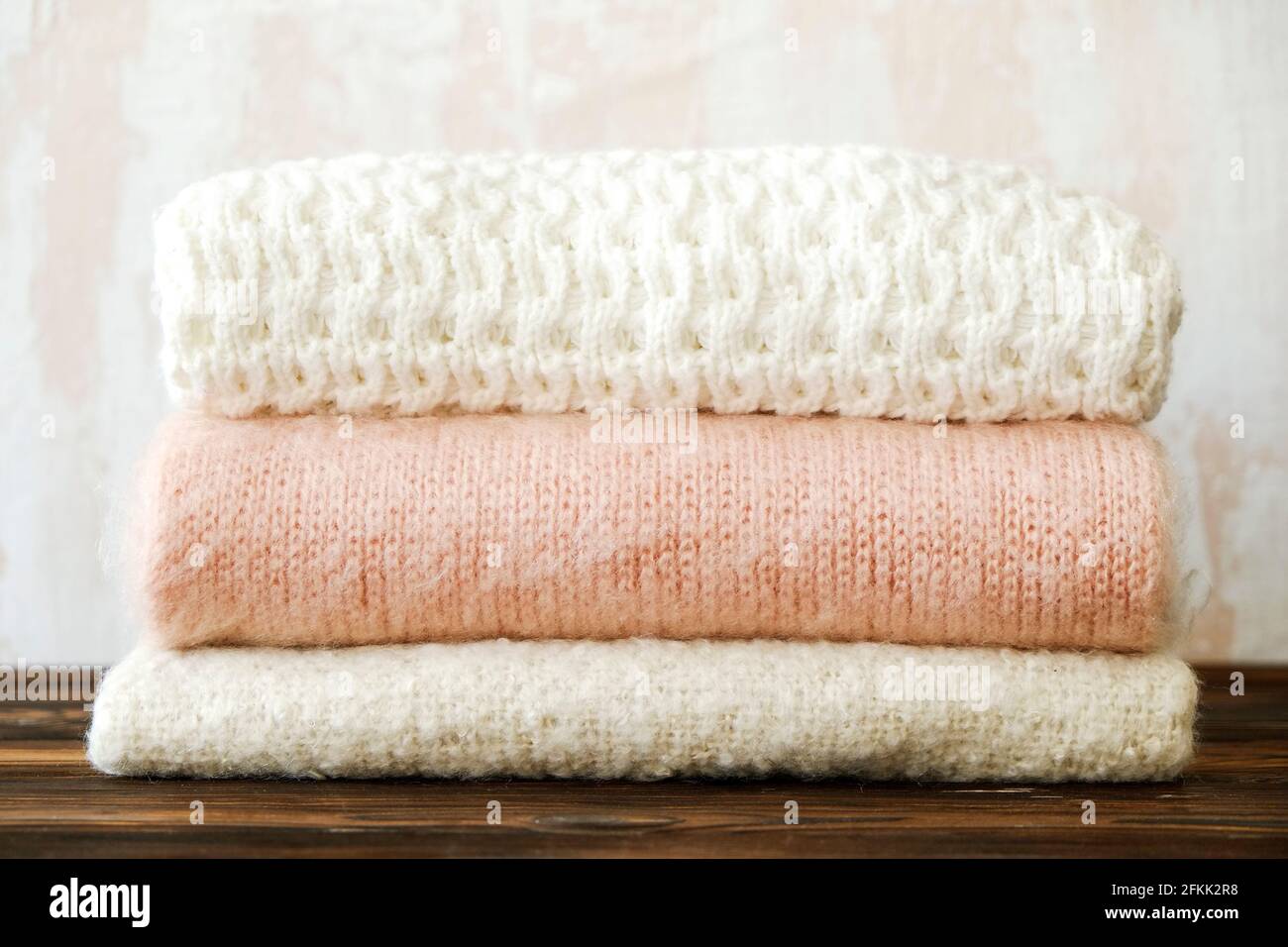 Bunch of knitted warm pastel color sweaters with different knitting ...