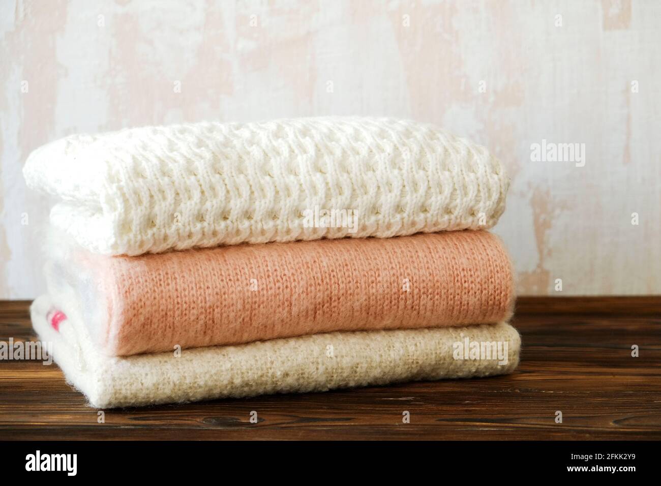 Bunch of knitted warm pastel color sweaters with different knitting ...