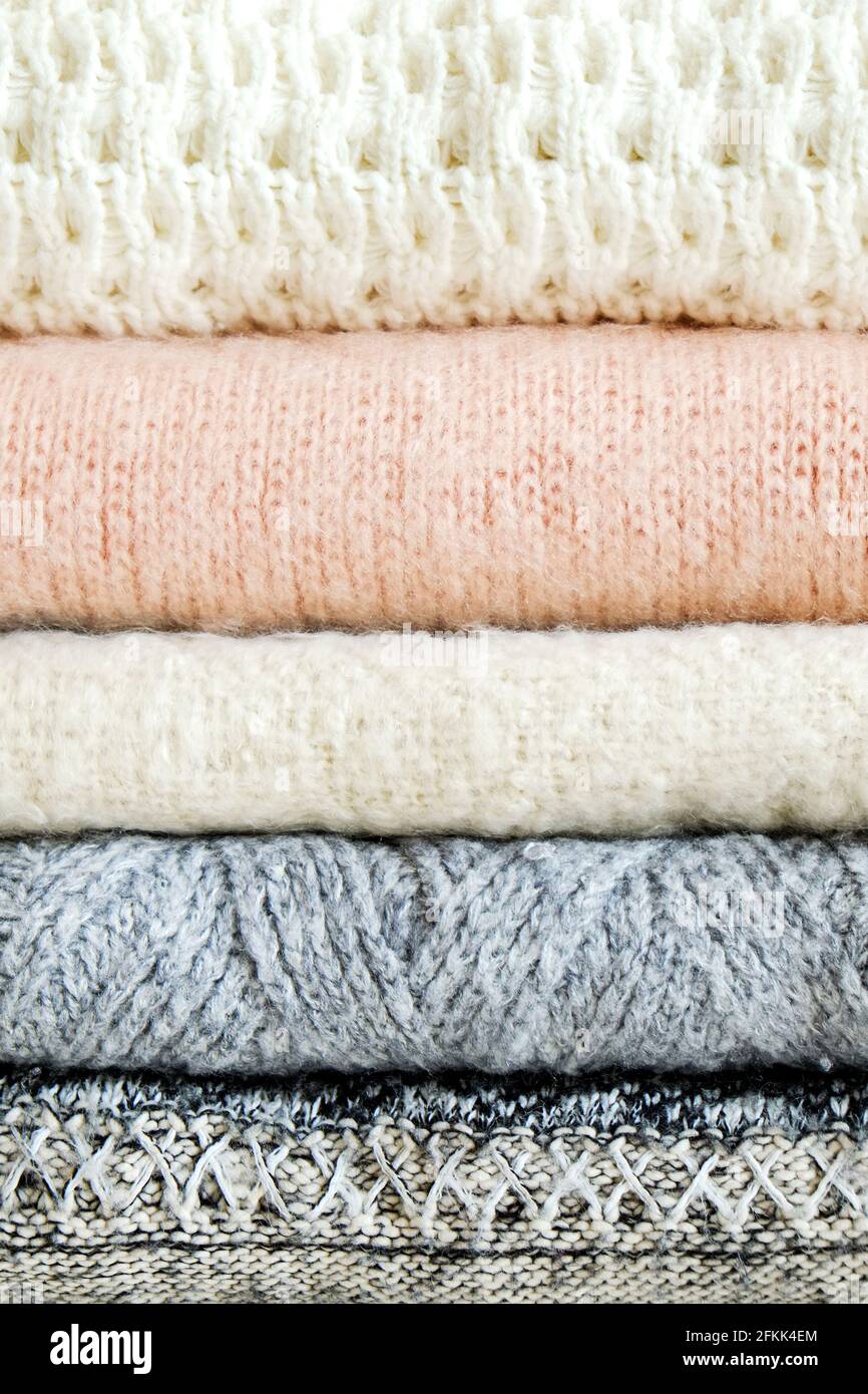 Bunch of knitted warm pastel color sweaters with different knitting ...