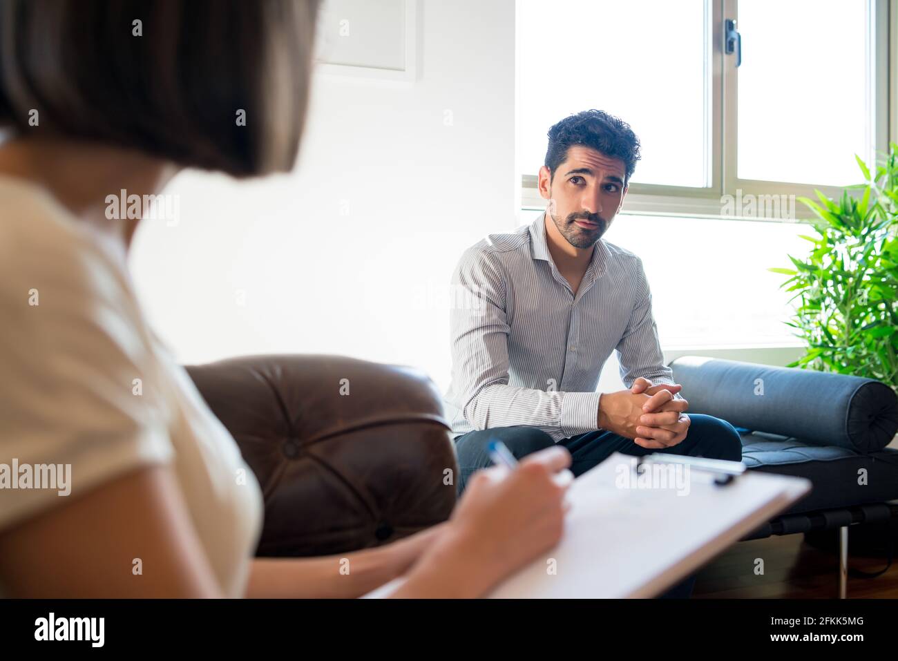 Psychologist taking notes during therapy session Stock Photo - Alamy