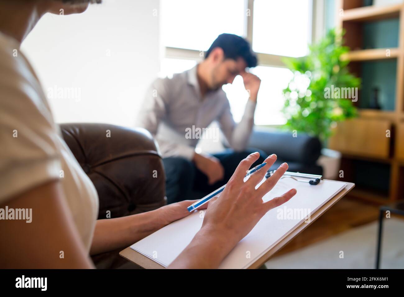 Psychologist taking notes during therapy session Stock Photo - Alamy