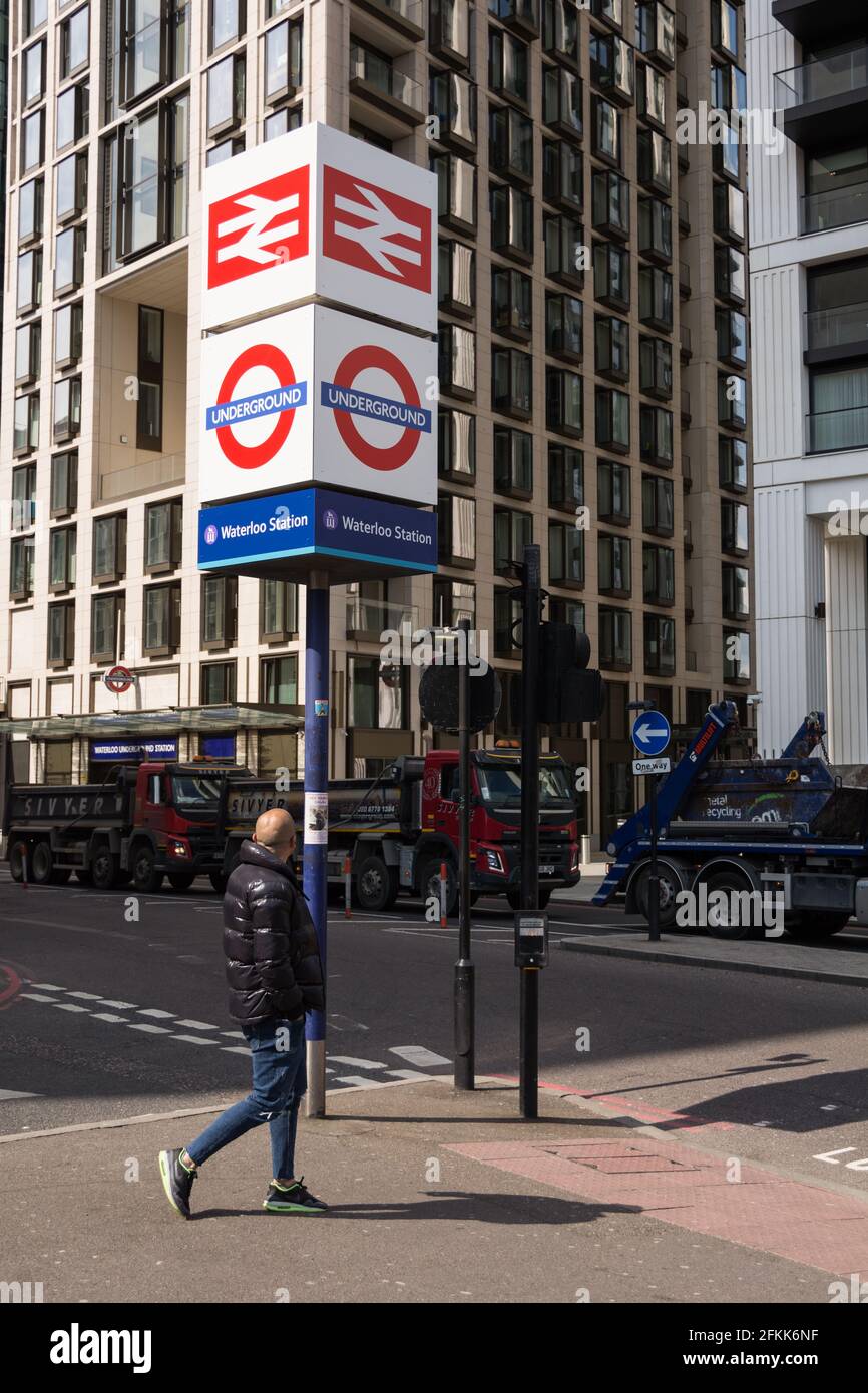 A man looking at Network Rail Waterloo Station signage and roundel ...