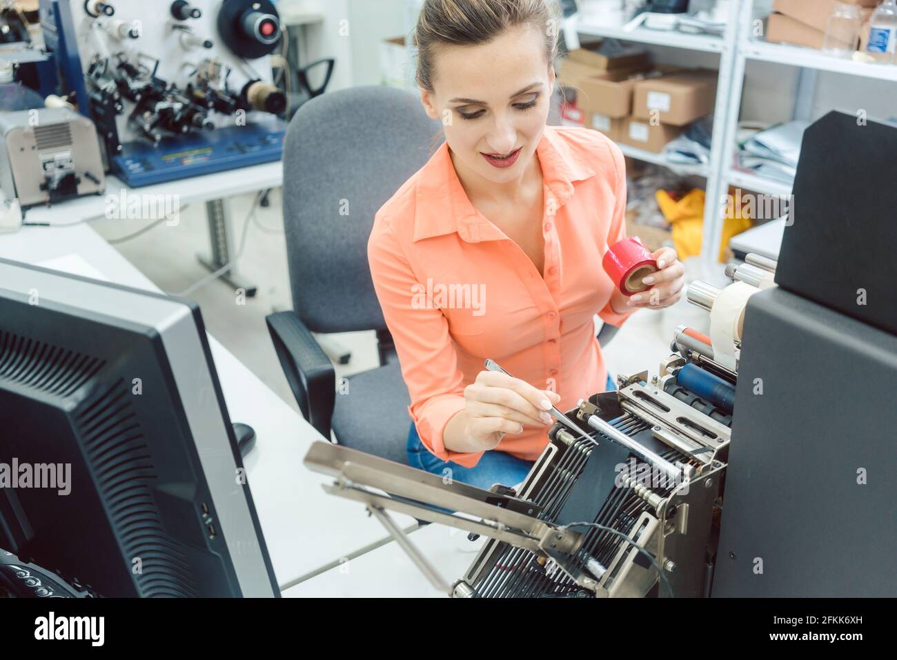 Woman working on label printing machine Stock Photo - Alamy