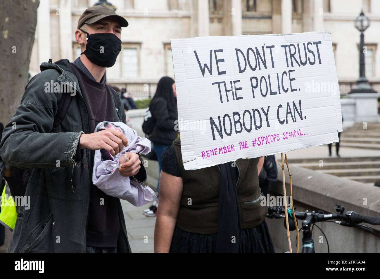 London, UK. 1st May, 2021. A woman holds a sign referring to the ...