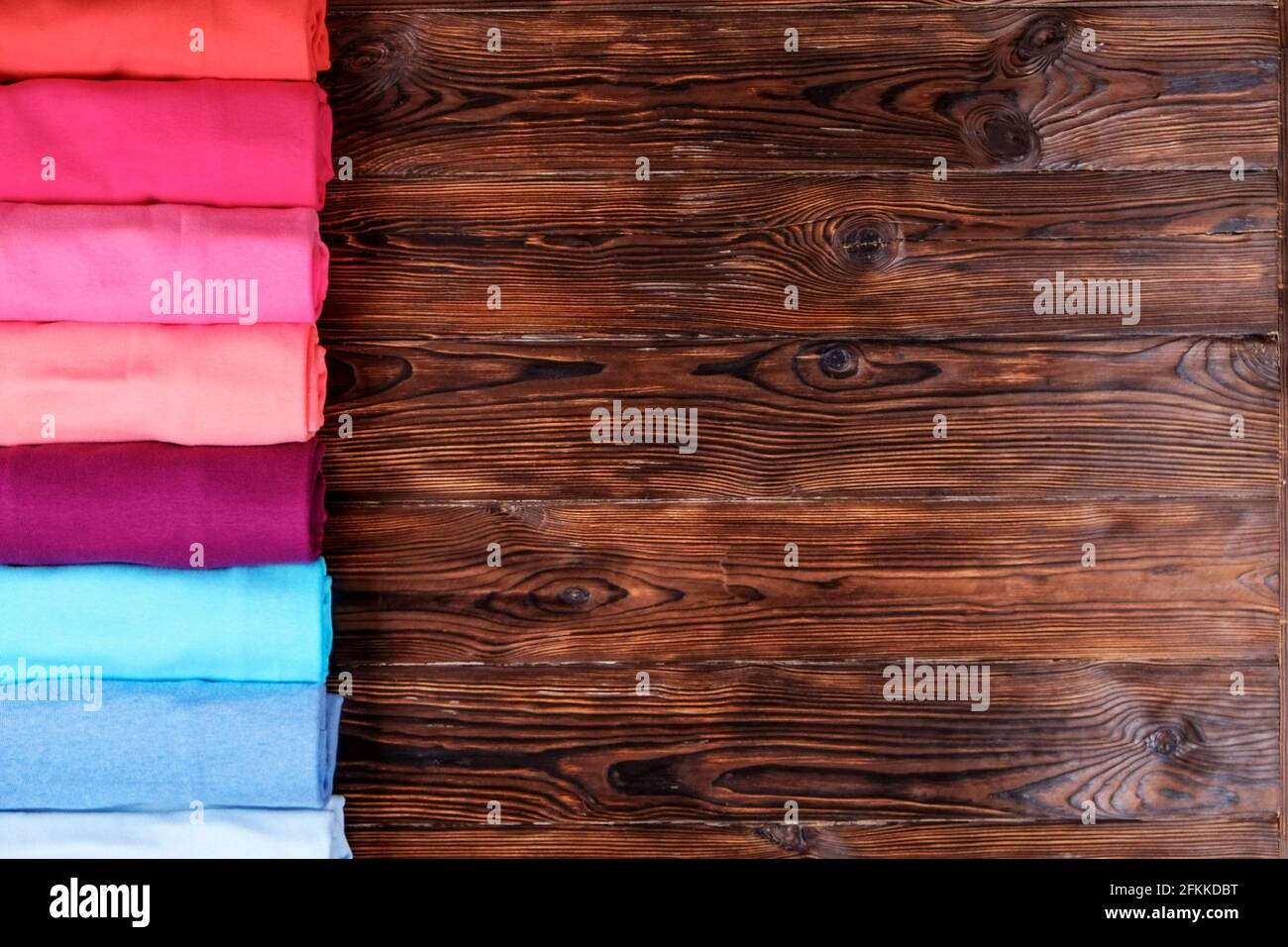 Close up of colorful clothes neatly rolled for saving luggage space ...