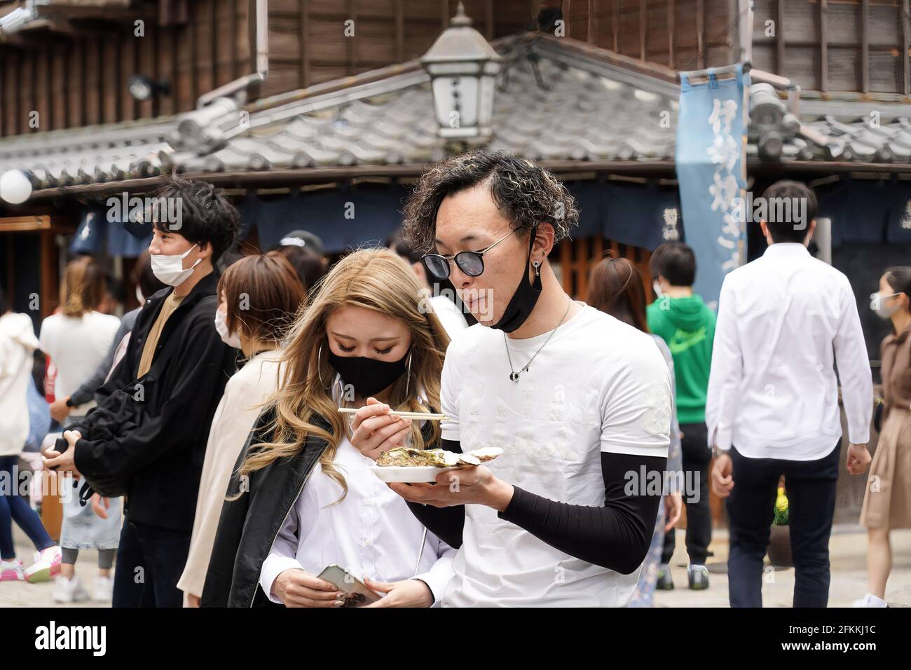 Ise, Japan. 02nd May, 2021. Travelers wearing face masks eat street ...