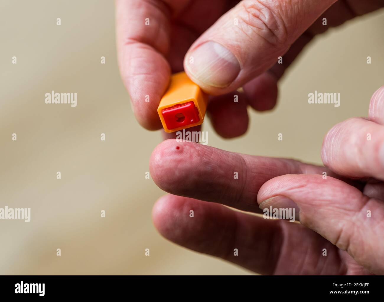 Man pricking finger with lancet for self testing medical blood test ...
