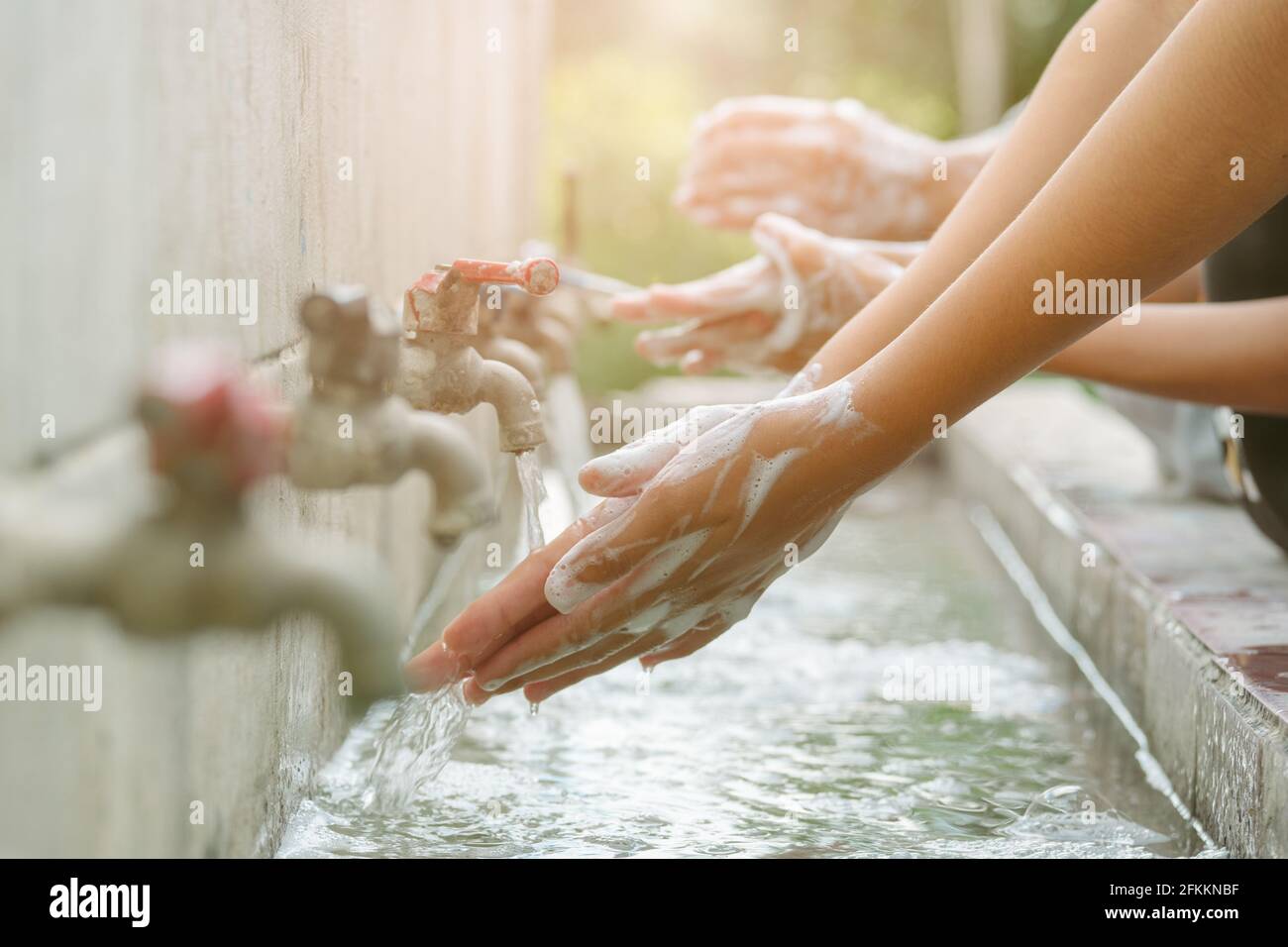 Close up hands of woman use soap and washing hands under the water tap ...