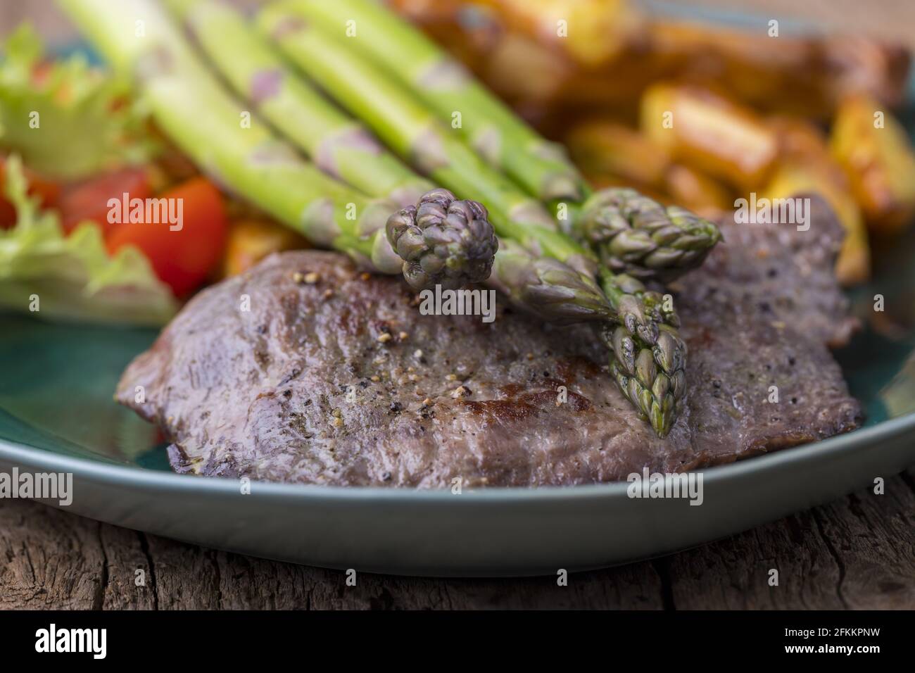 asparagus on a grilled steak with fries Stock Photo - Alamy