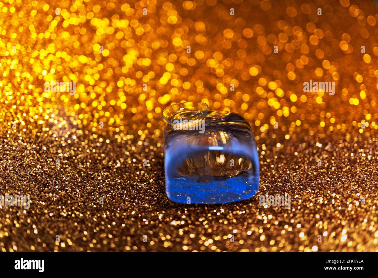 Contact lens on ice in golden background Stock Photo - Alamy