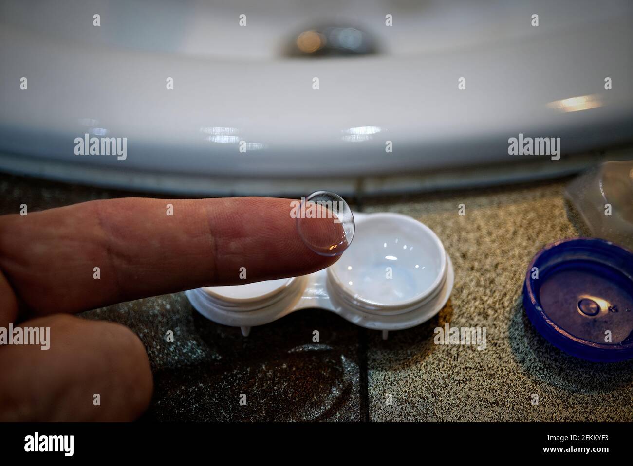 Putting on contact lens with your finger Stock Photo - Alamy