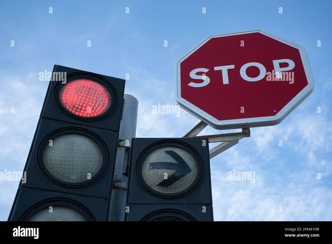 traffic light and traffic sign viewed from below with sky and clouds in ...