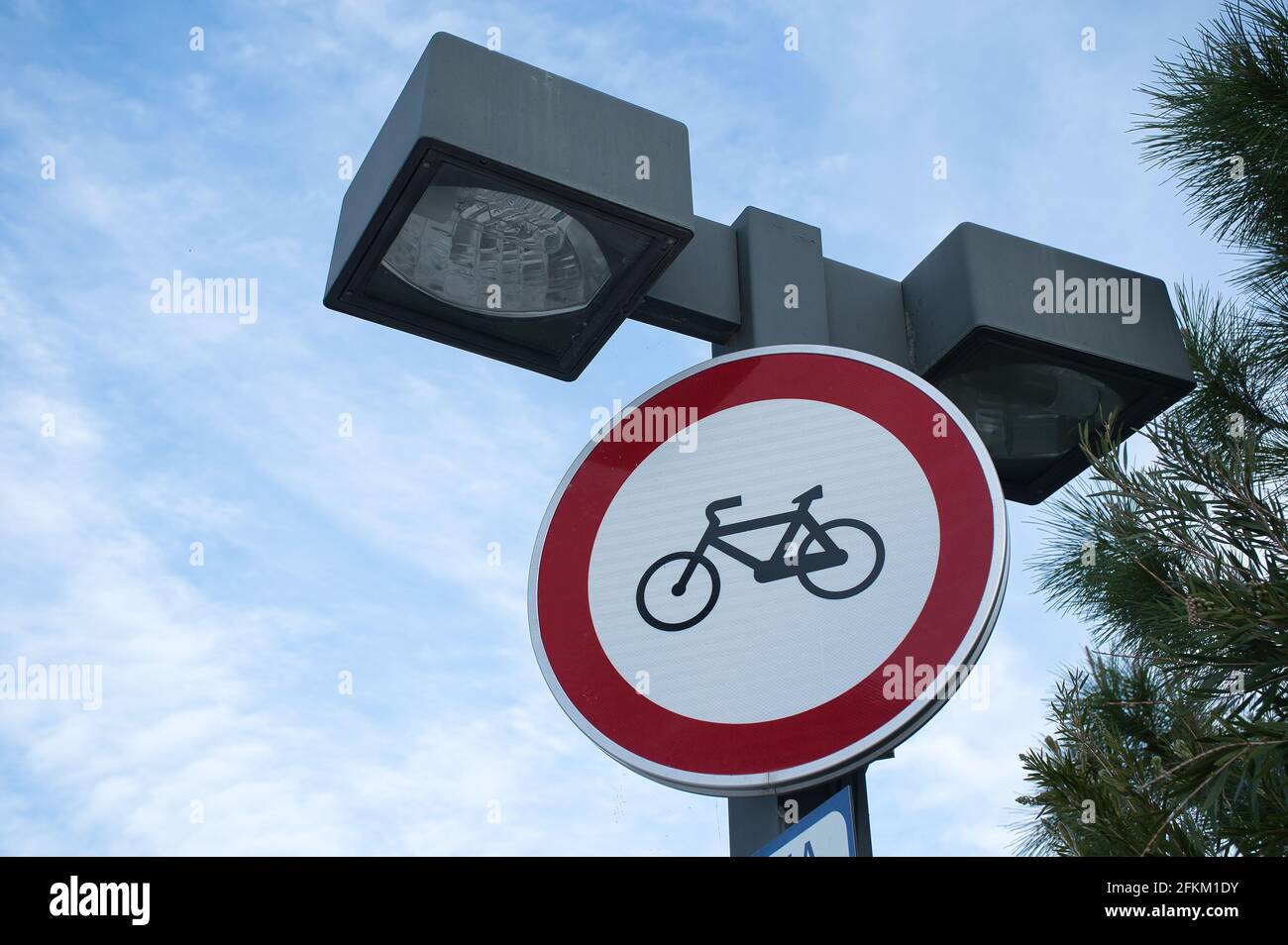 streetlight and traffic sign viewed from below with sky and clouds in ...