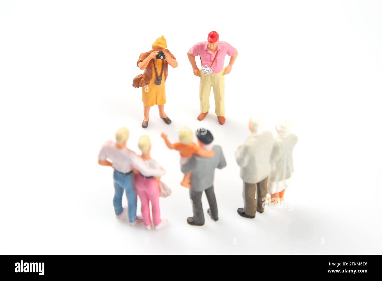 miniature people. photographer takes pictures of people on a white ...