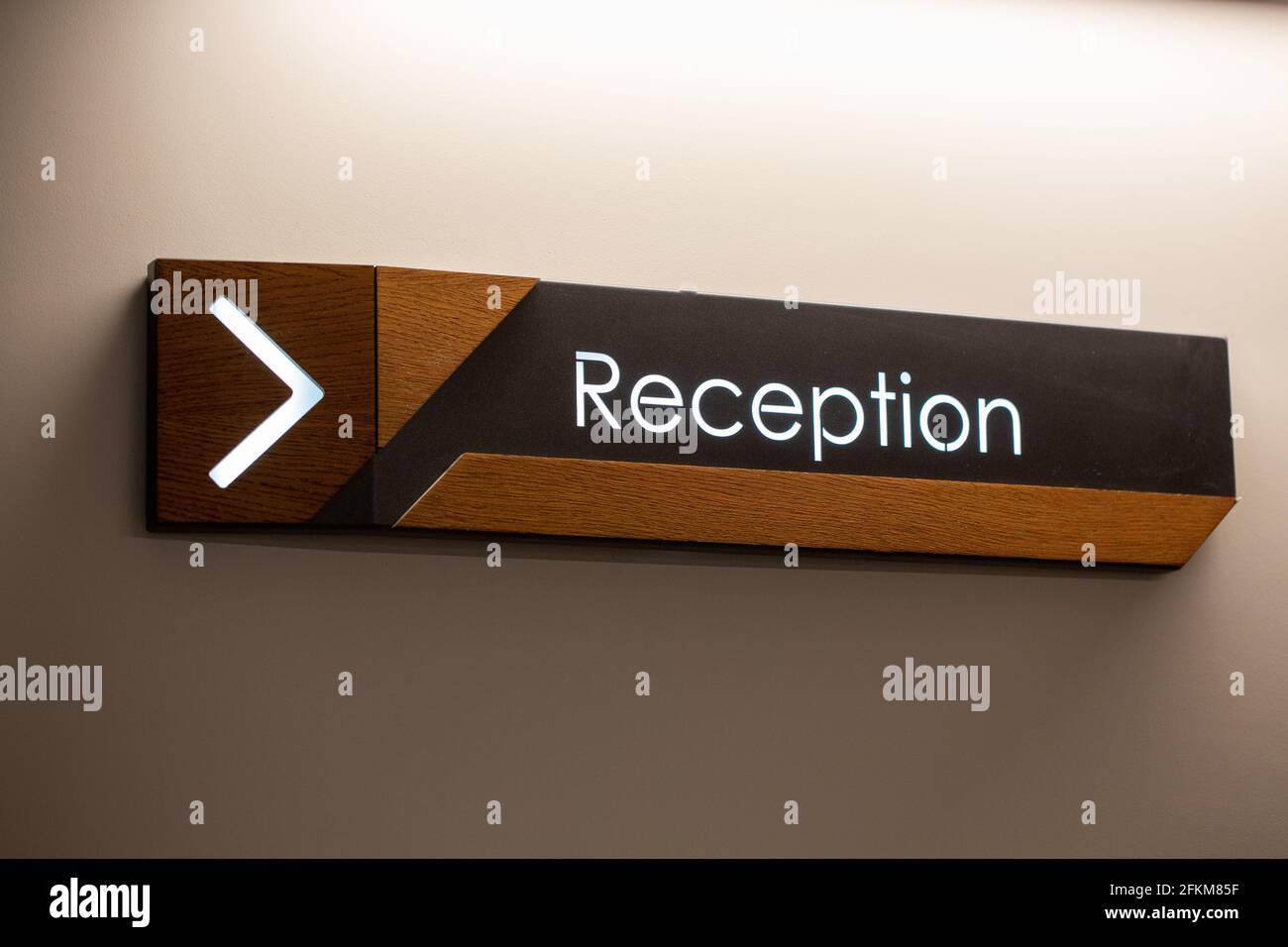 The reception sign with direction arrow on the wall Stock Photo - Alamy