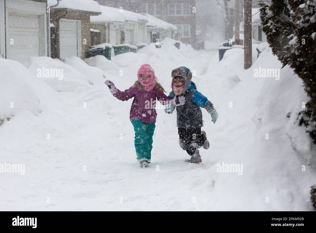 Two children playing in the alley during a snowstorm Stock Photo - Alamy