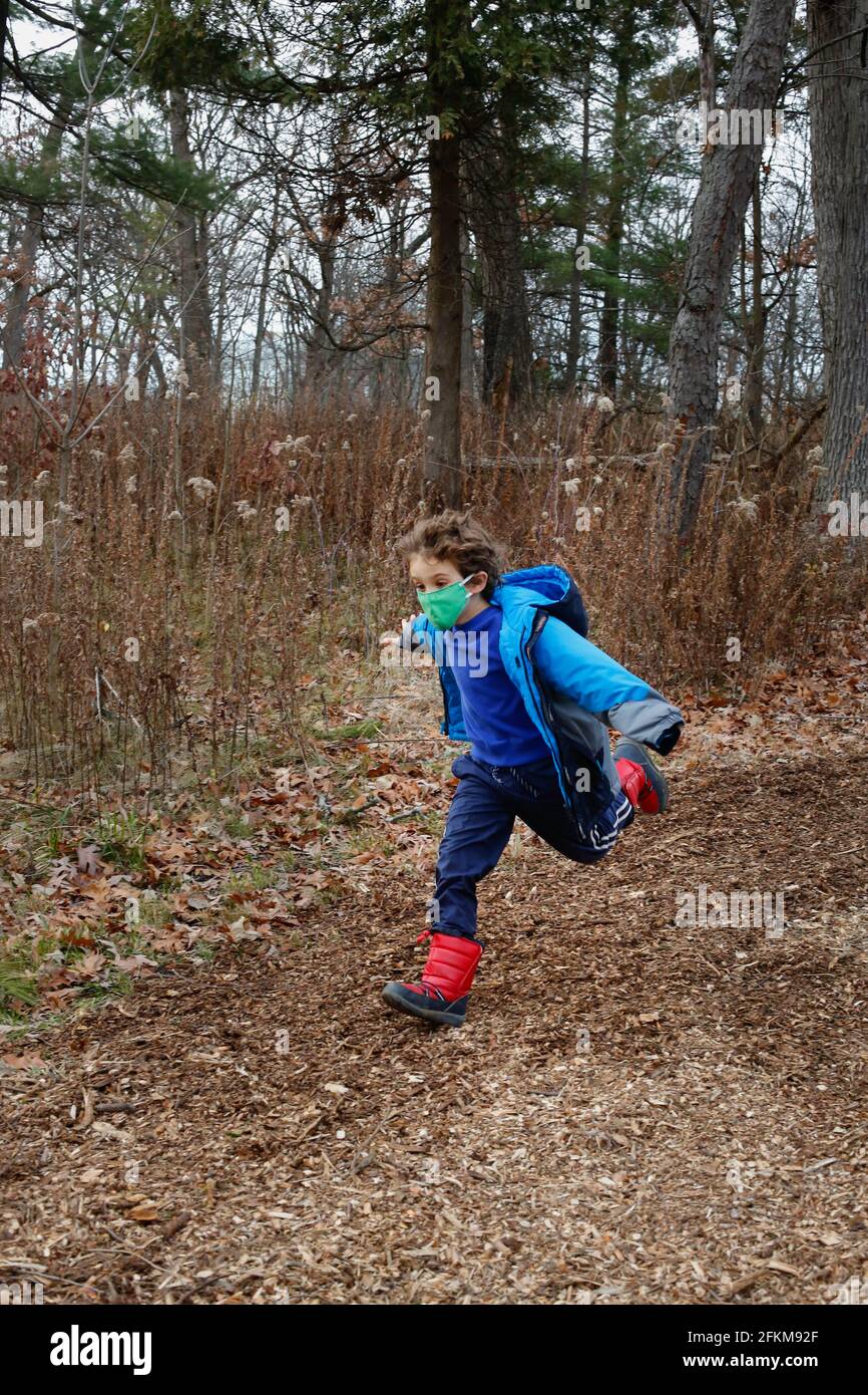 A boy running through the woods on a fall day Stock Photo - Alamy