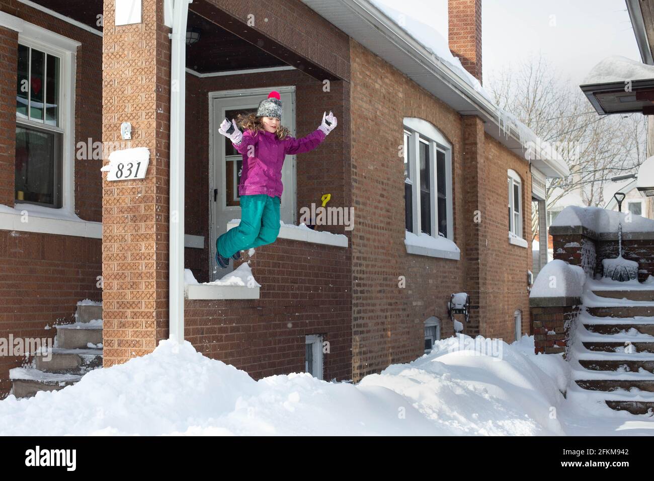 Girl jumping into the snow urban environment Stock Photo - Alamy