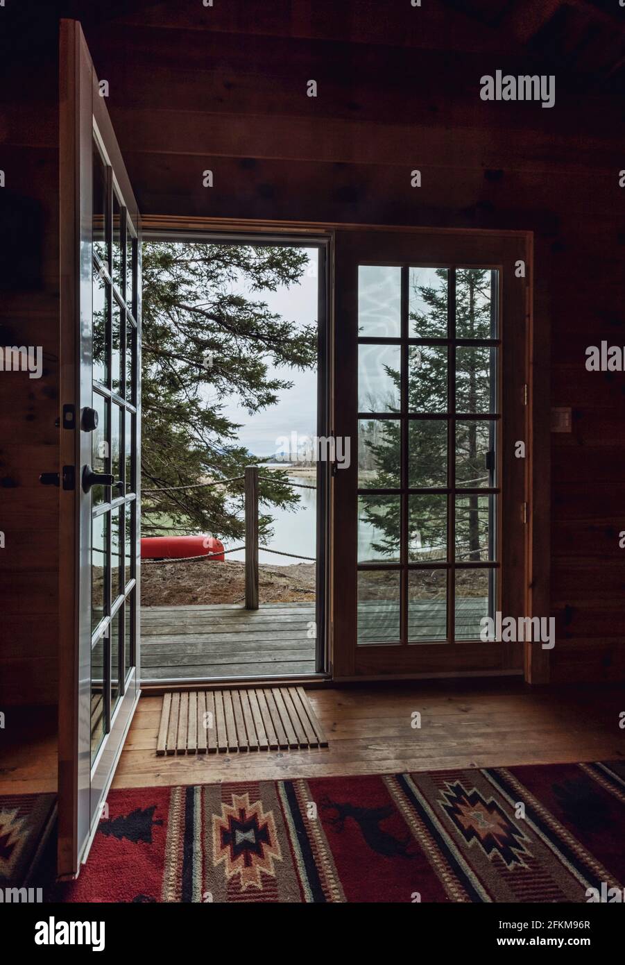 Interior view through open door at woods and water view, coastal Maine ...