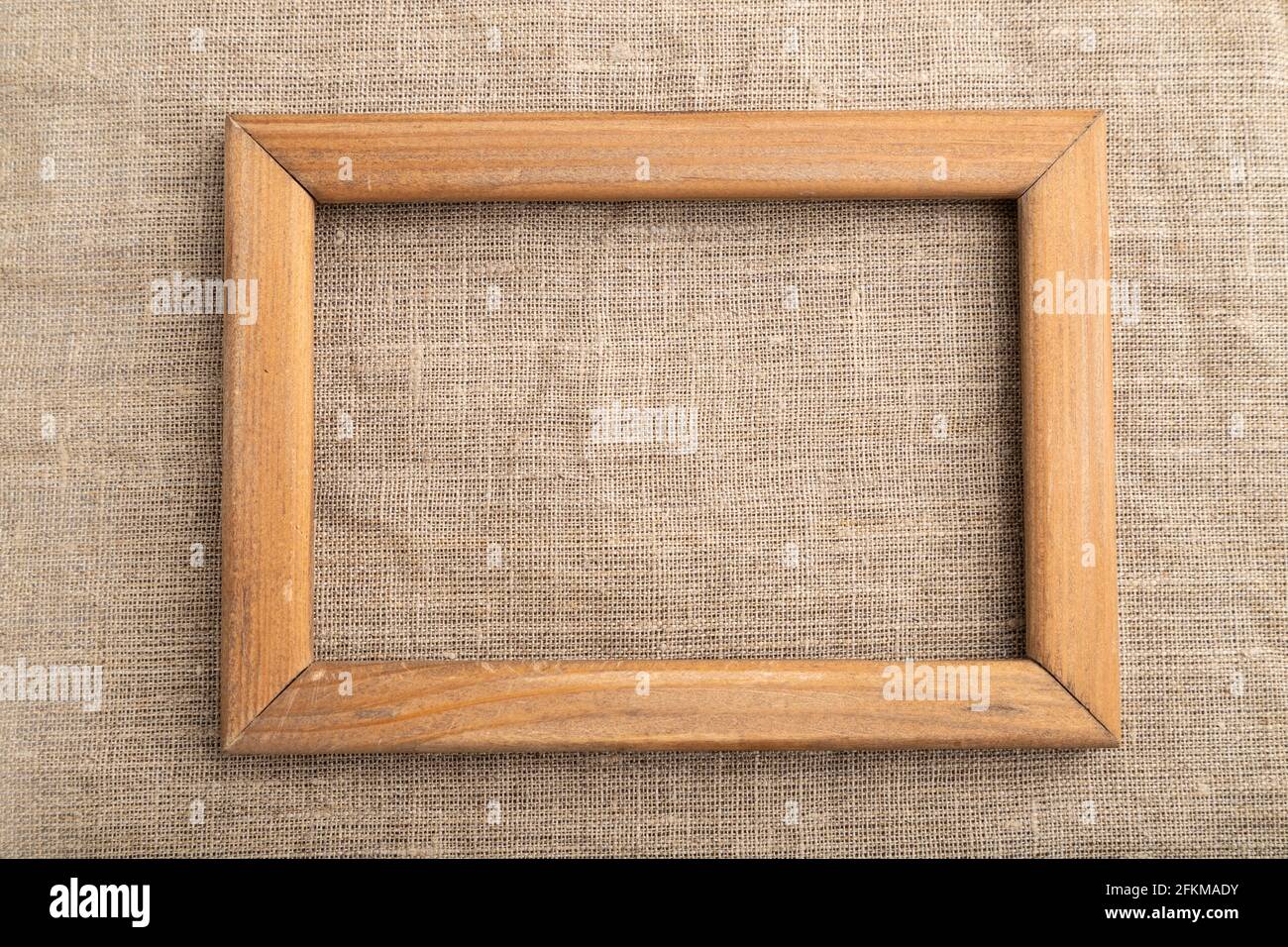 Wooden frame on smooth brown linen tissue. Top view, flat lay, natural ...
