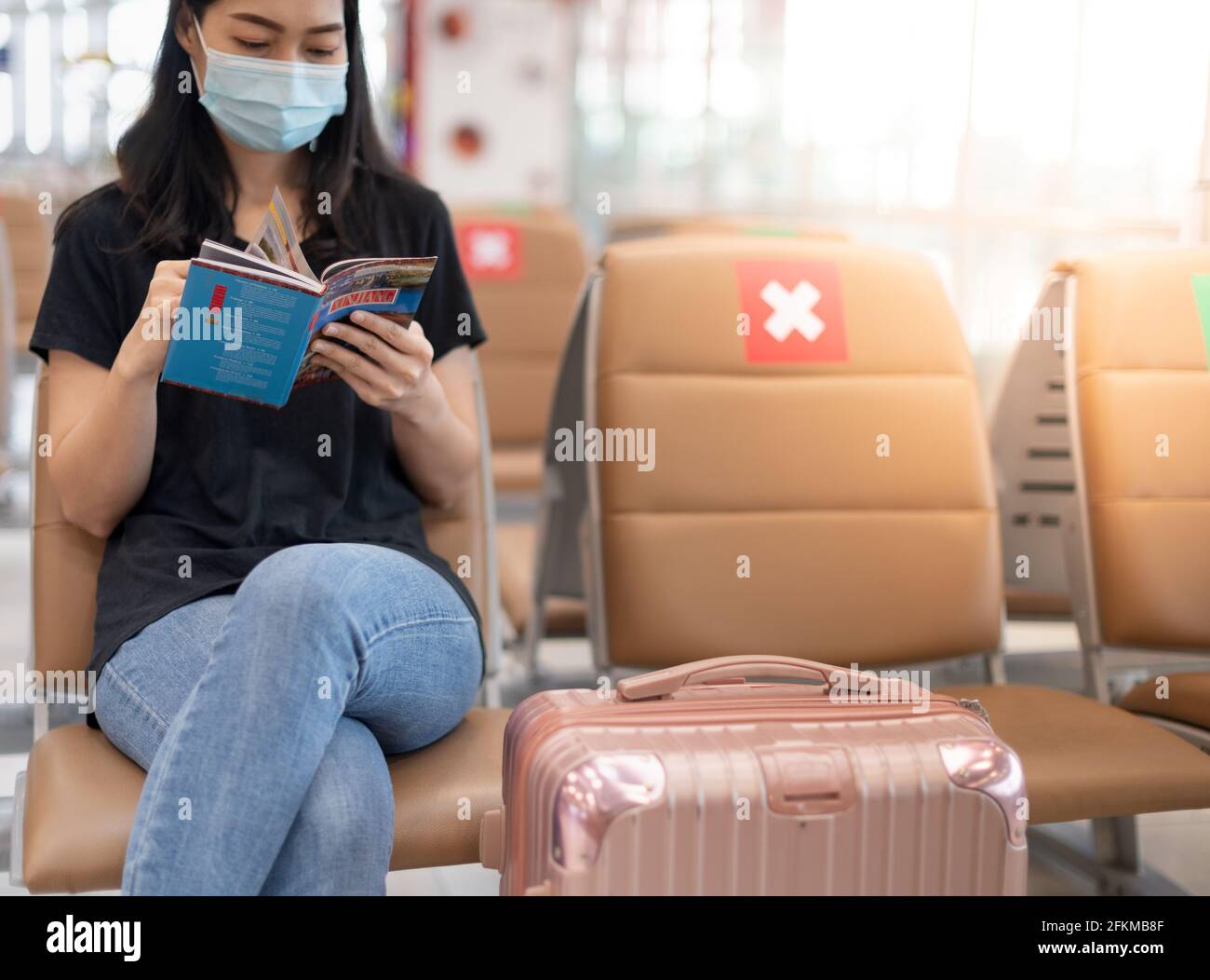 Asian girl traveler wearing surigal mark with carry on luggage in ...