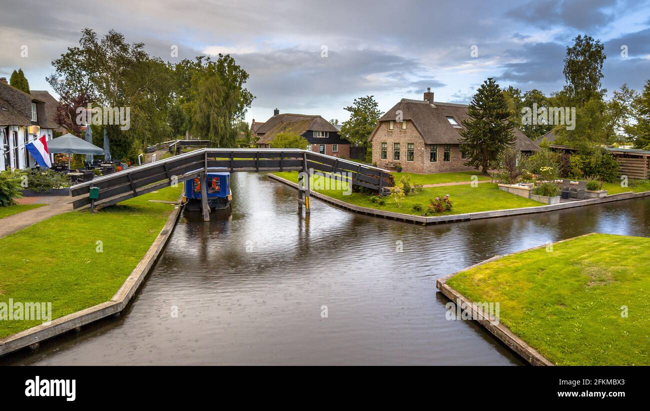 Landscape view of famous Giethoorn village with canals and rustic thatched roof houses in farm ...