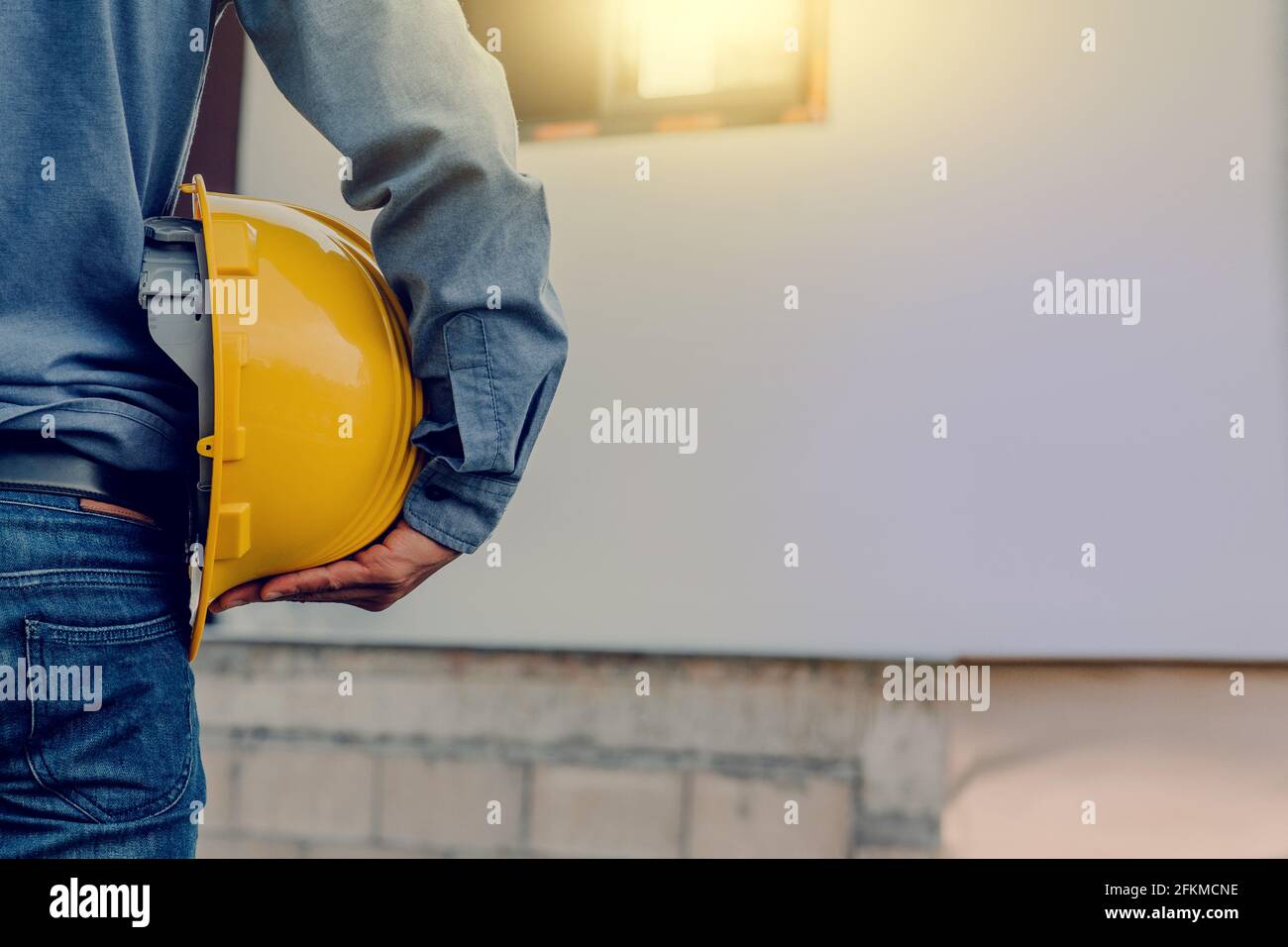 Contractor holding yellow helmet on site building construction ...